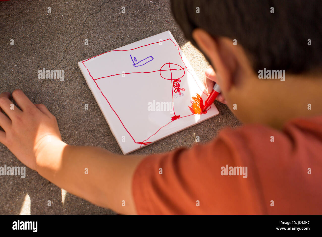 Mixed Race boy drawing on paper with marker Stock Photo - Alamy