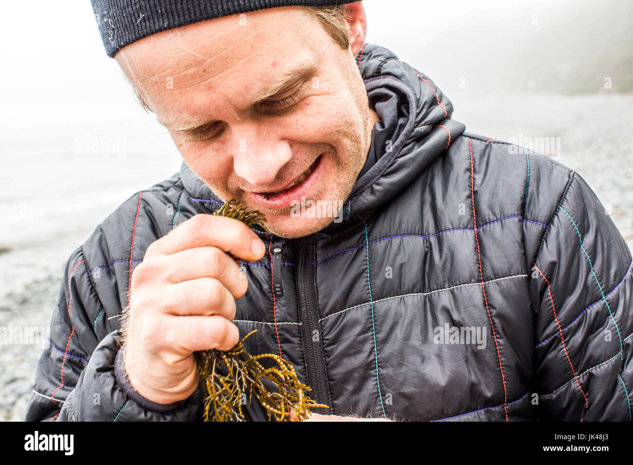 Caucasian man biting seaweed near ocean Stock Photo - Alamy