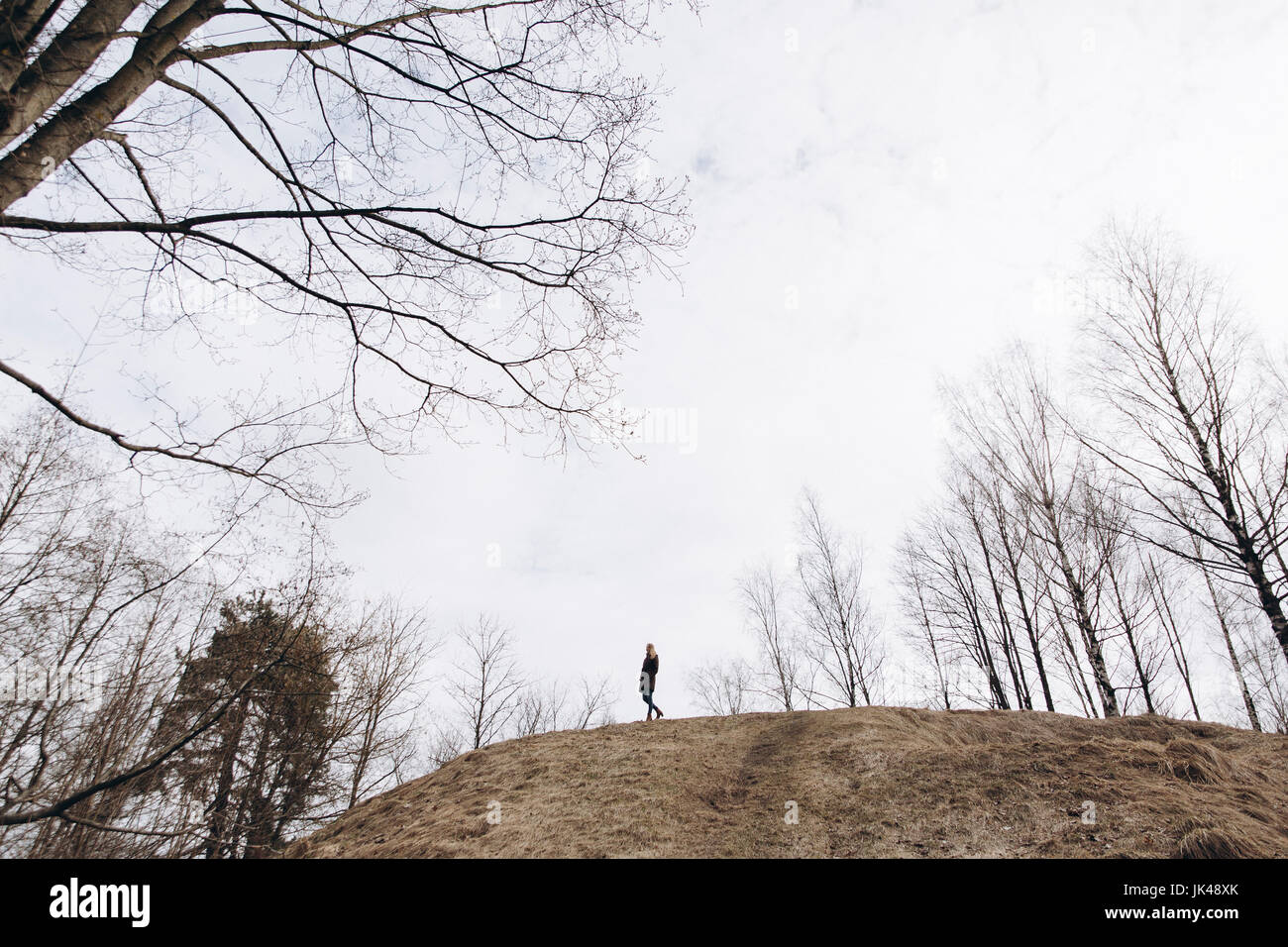 Distant woman standing on hill Stock Photo - Alamy
