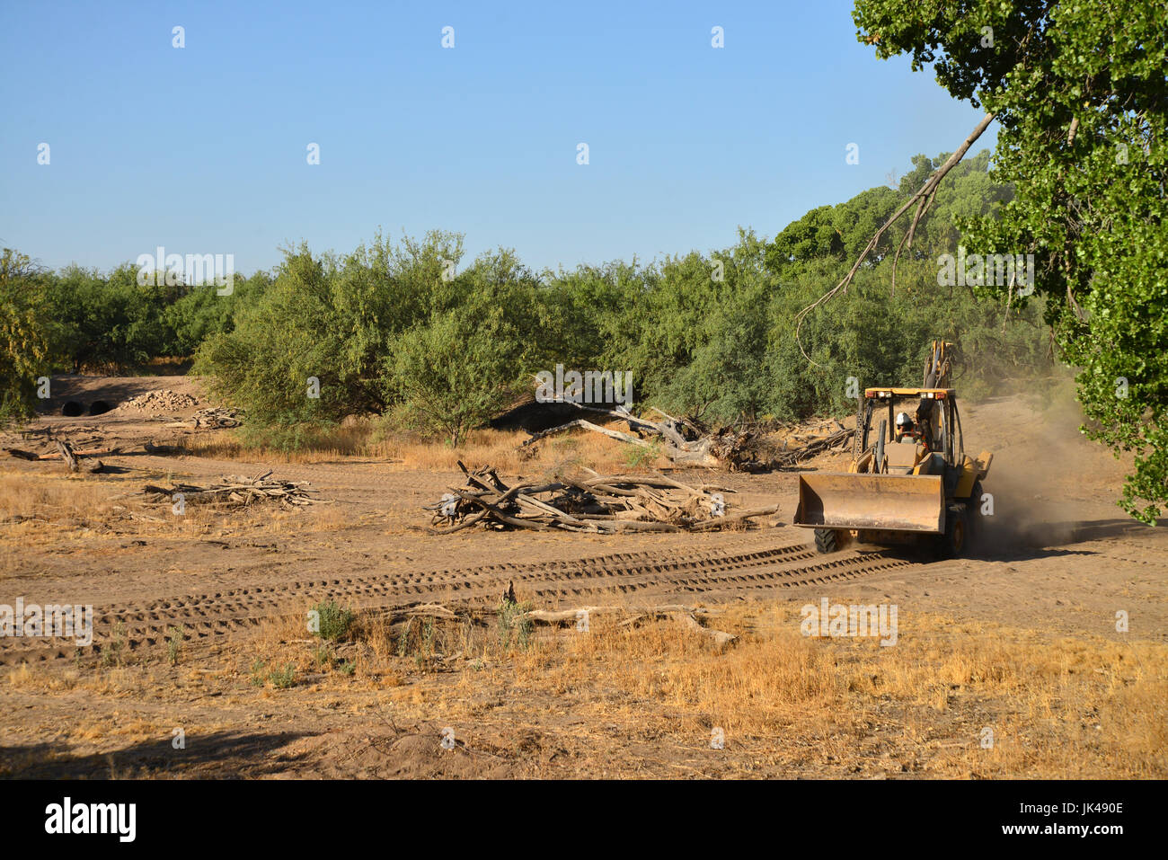 An operator of heavy equipment covers his face to protect himself from ...