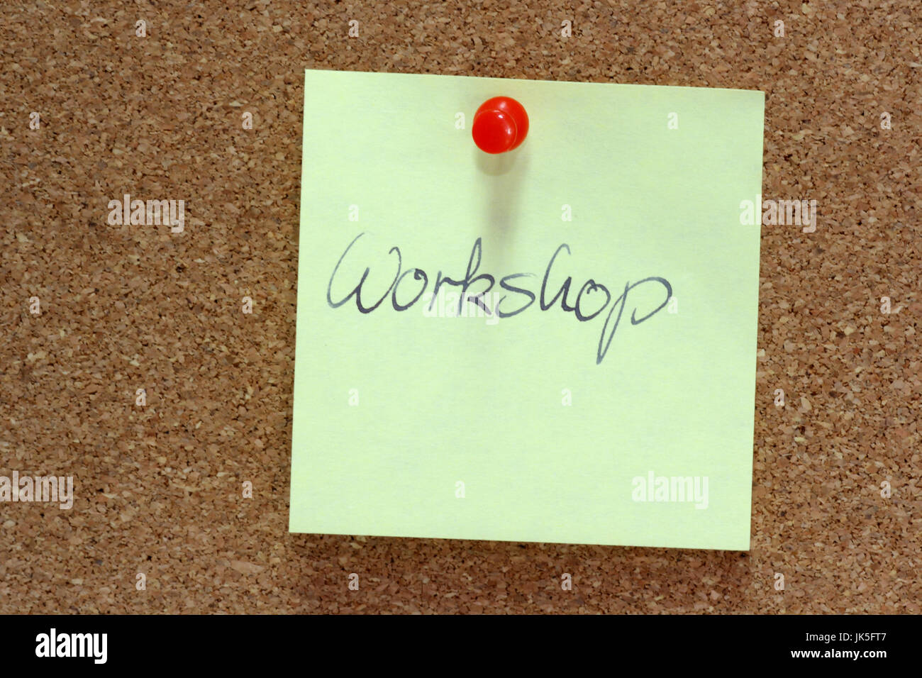 Yellow post-it note on bulletin board of cork Stock Photo - Alamy