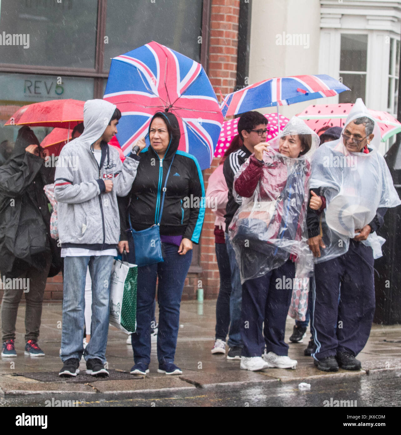 Visitors shelter rain under umbrellas hi-res stock photography and ...