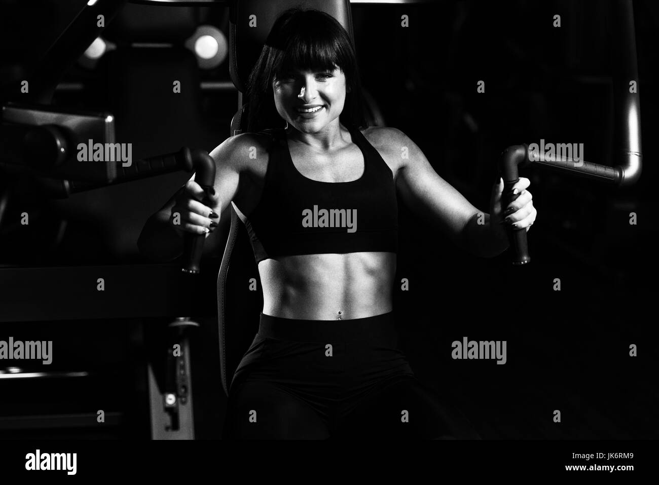 Fitness Woman Doing Heavy Weight Exercise For Chest On Machine With ...