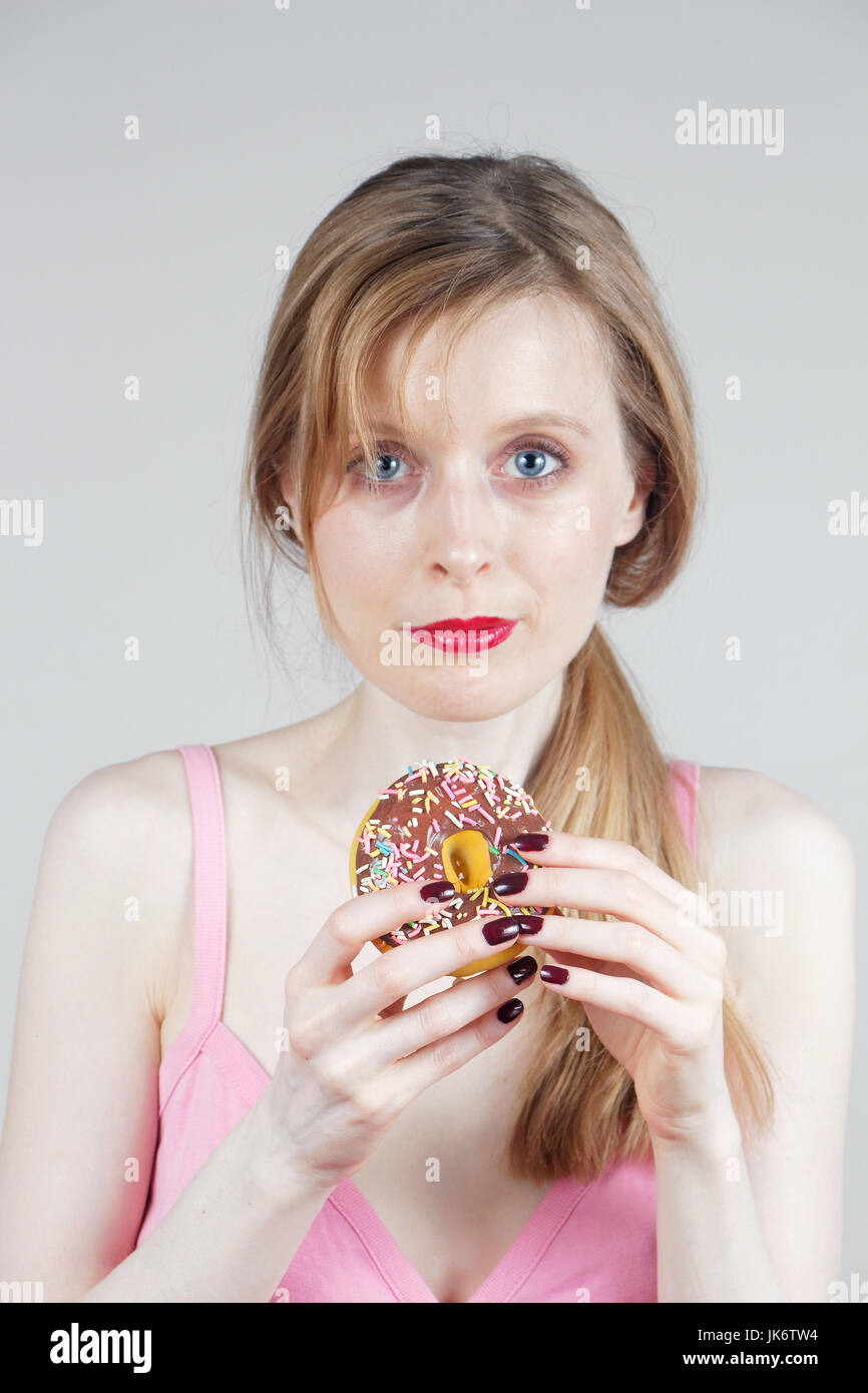 Young beautiful girl holding sweet donut in her hand Stock Photo - Alamy