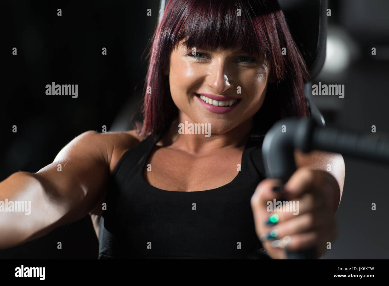 Fitness Woman Doing Heavy Weight Exercise For Chest On Machine With ...