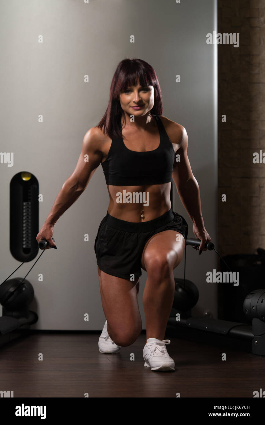Young Woman Is Working On Her Legs With Cable Crossover In A Modern ...