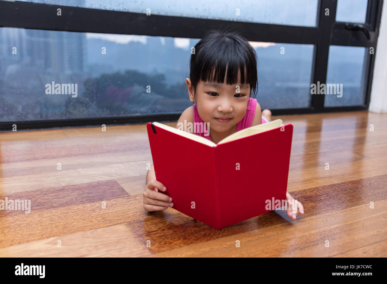 Asian little Chinese girl reading a book near the window at home Stock ...