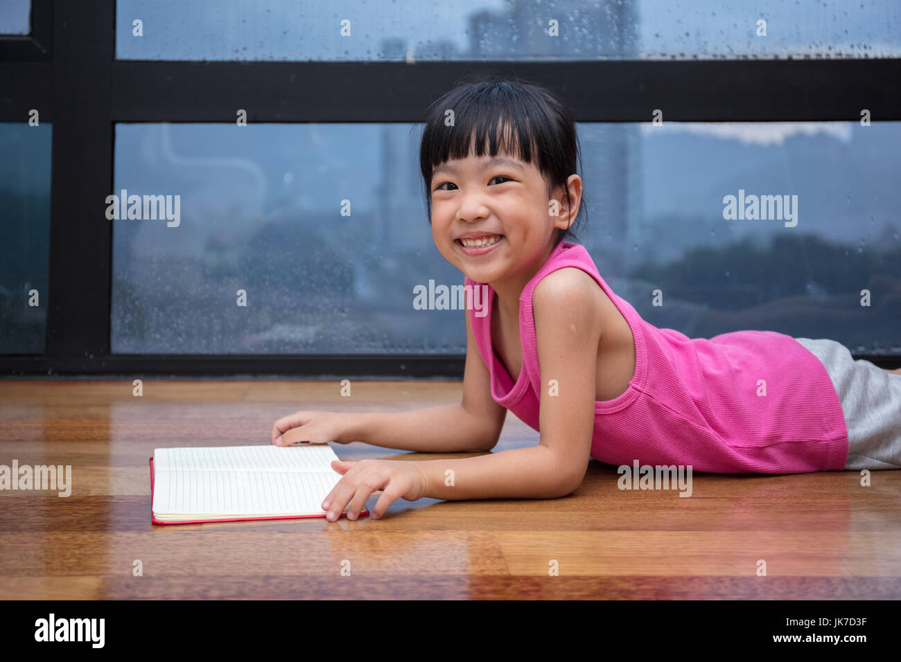 Asian little Chinese girl reading a book near the window at home Stock ...