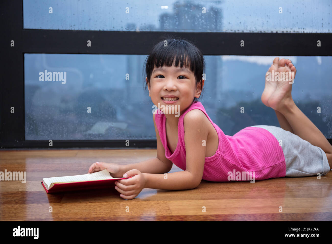 Asian little Chinese girl reading a book near the window at home Stock ...