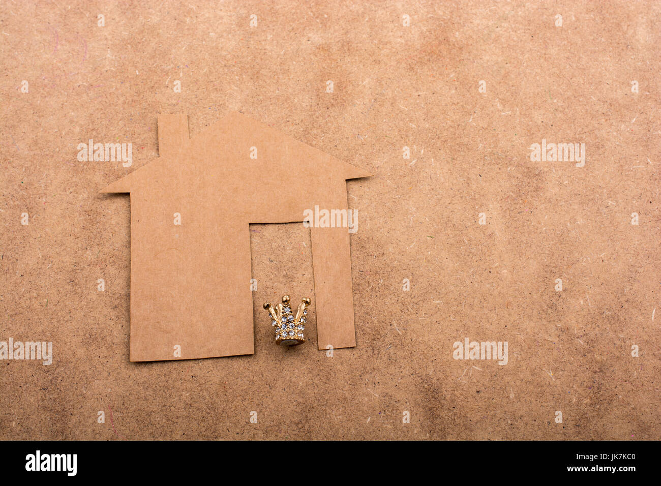 Litle model crown and paper house on a brown background Stock Photo - Alamy