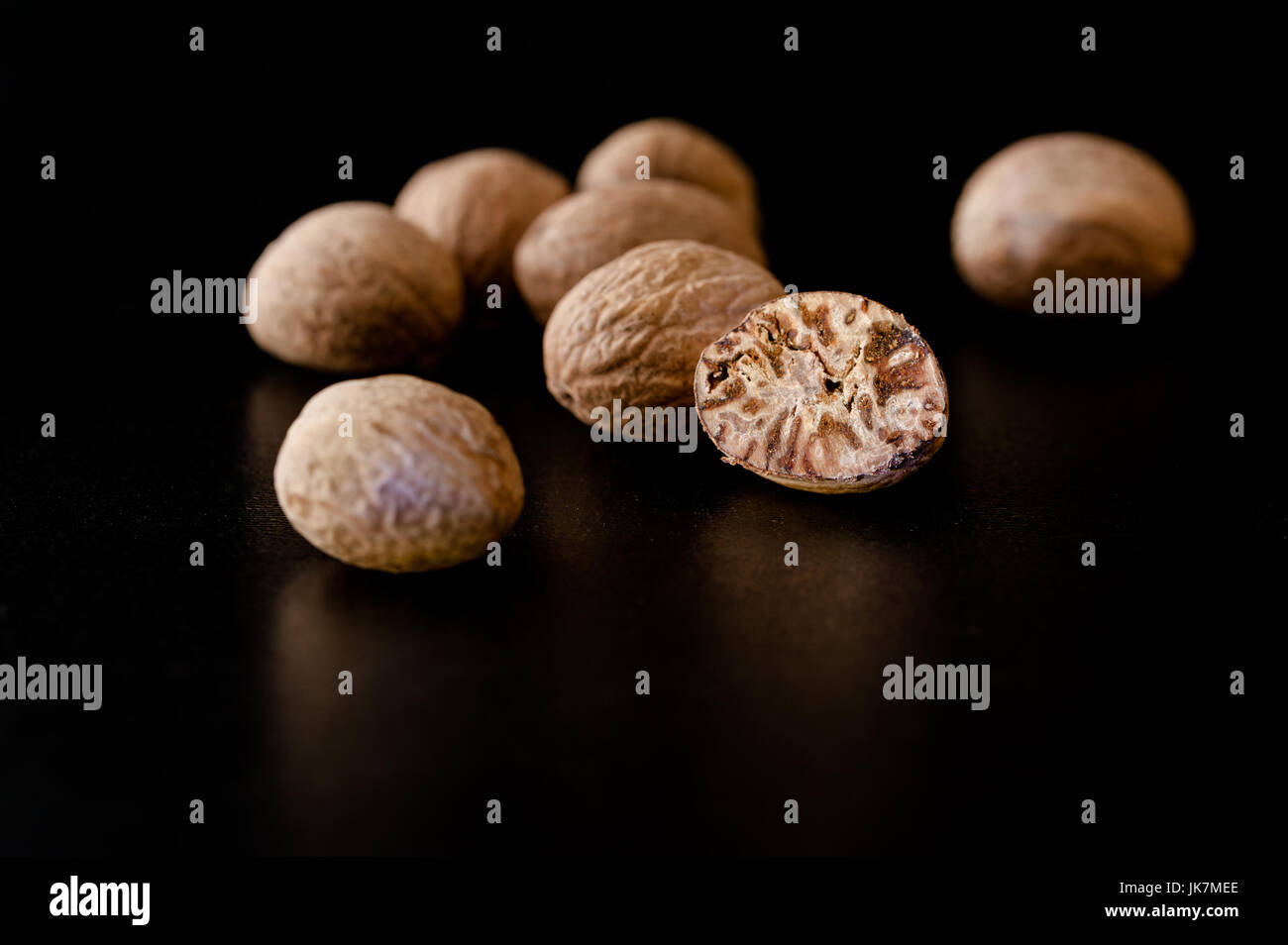 Nutmeg nuts and powder isolated on dark background Stock Photo - Alamy