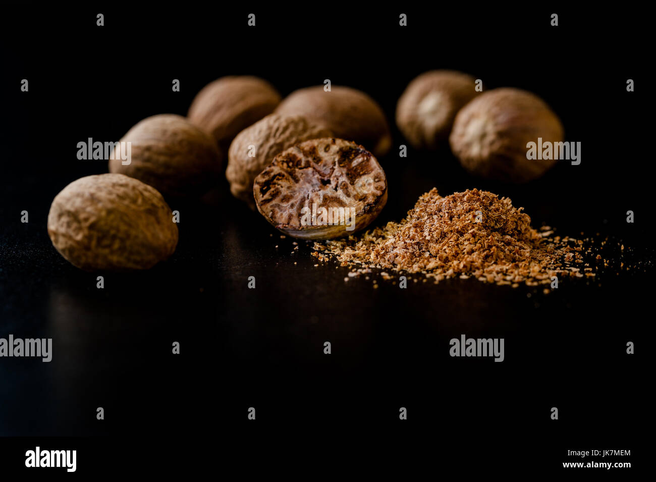 Nutmeg nuts and powder isolated on dark background Stock Photo - Alamy