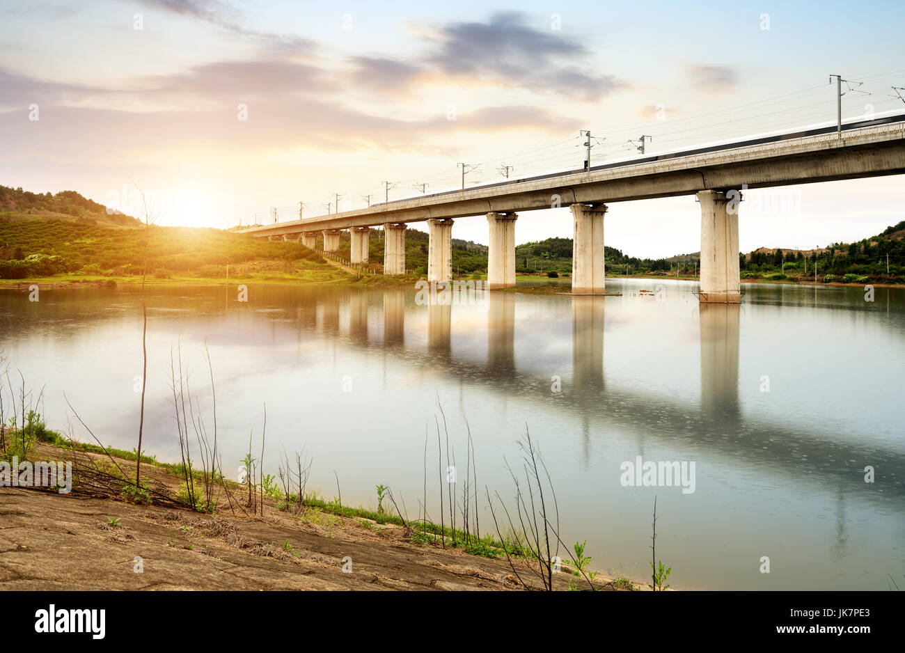 High speed trains through the bridge, dusk landscape Stock Photo - Alamy