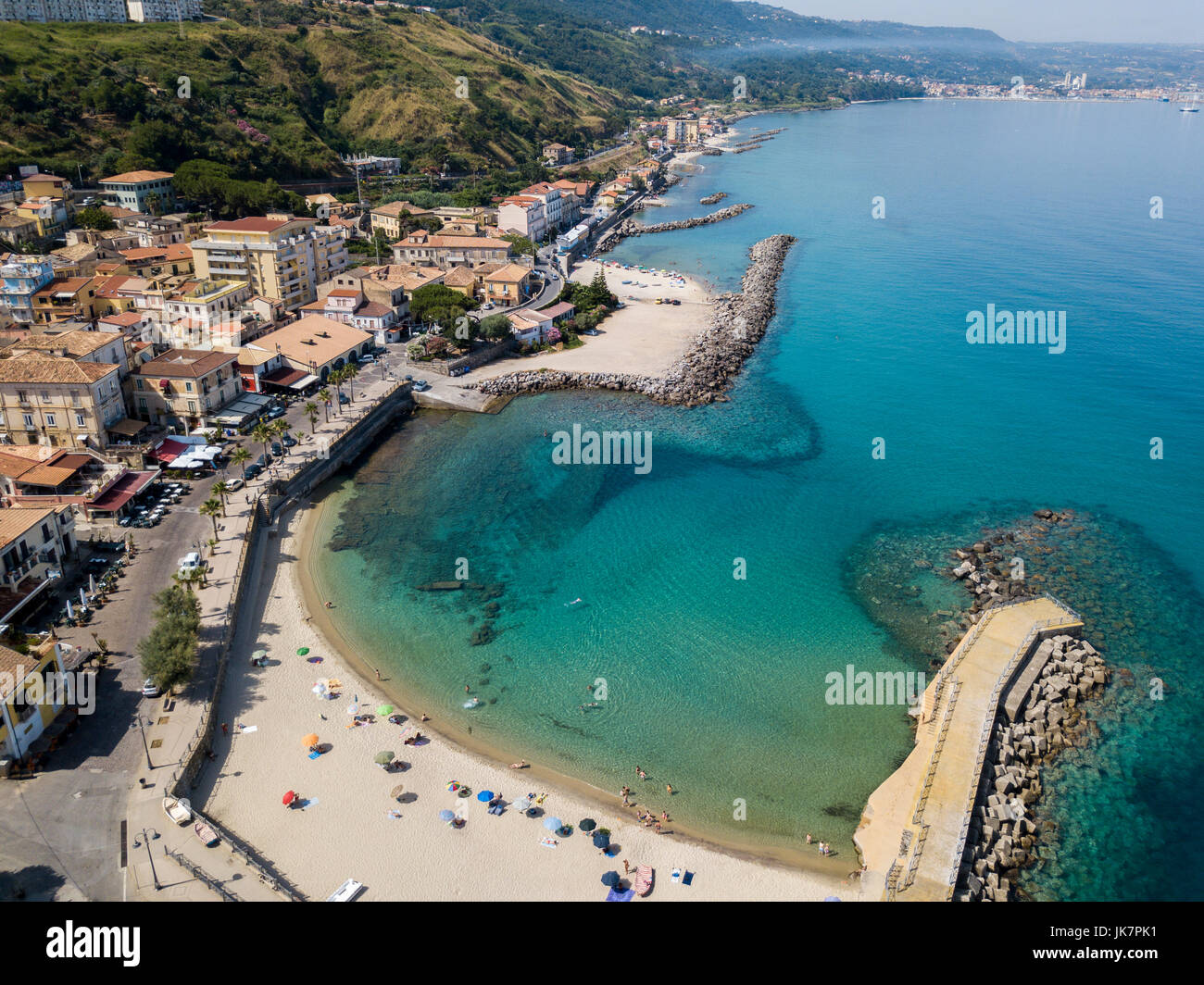Aerial view of a beach and a pier with canoes, boats and umbrellas ...