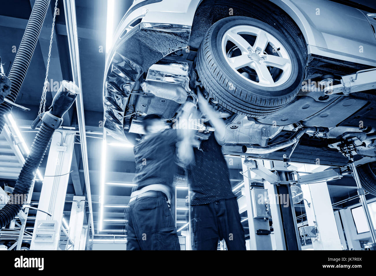 The technician is repairing the car, the blue hue Stock Photo - Alamy