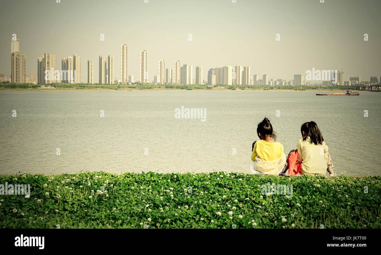 Girl sitting on the river watching the river Stock Photo - Alamy