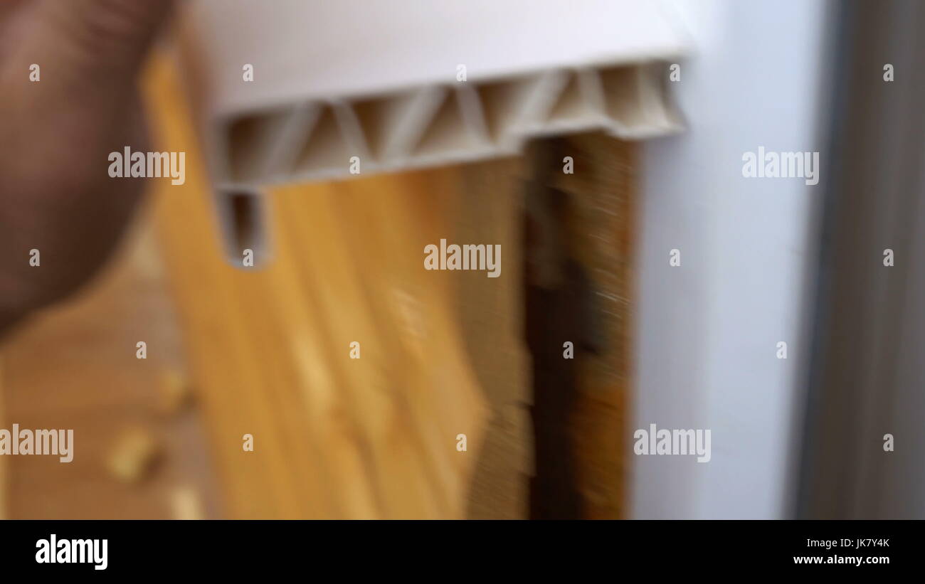 Nozzle of construction gun fills space under window frame by ...
