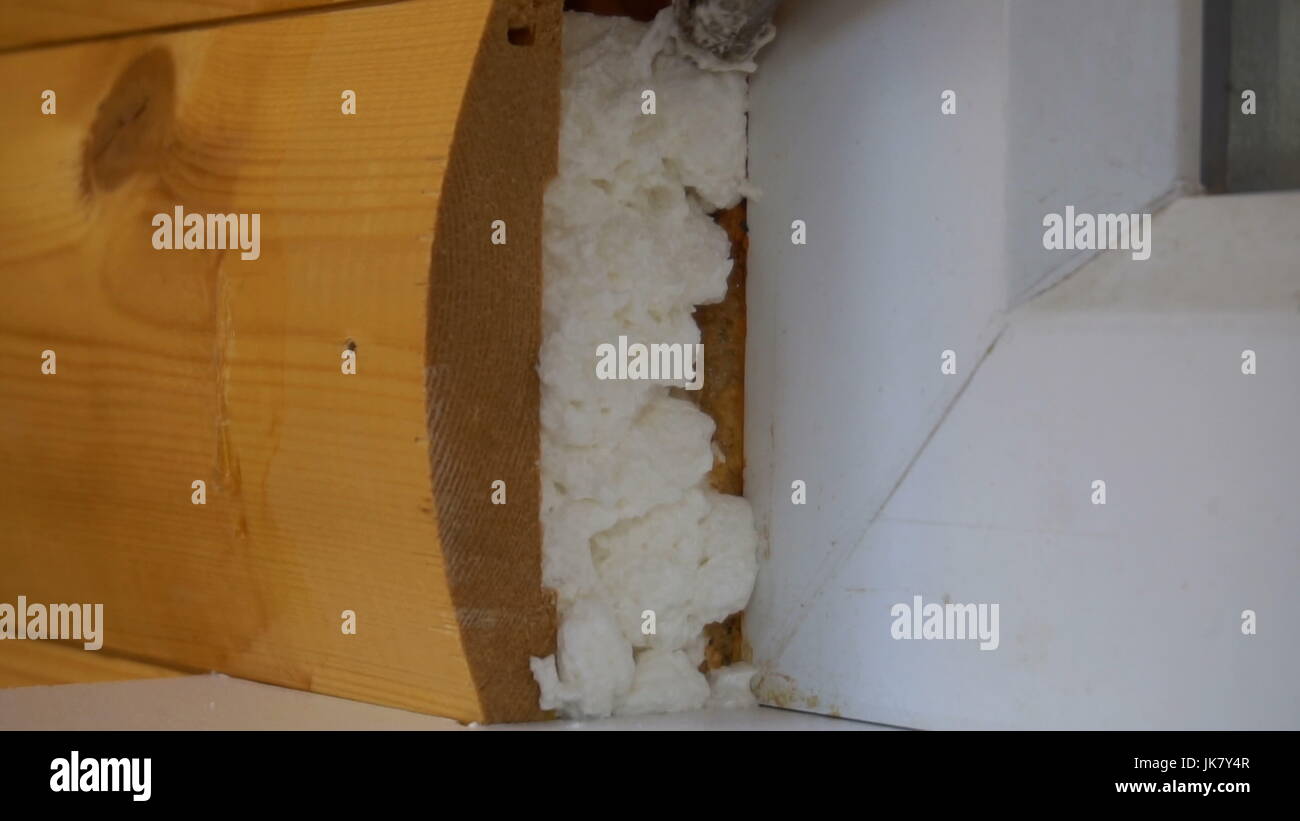 Nozzle of construction gun fills space under window frame by ...