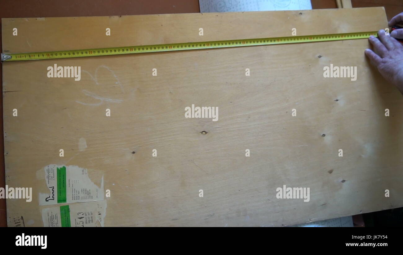 worker measures with tape measure hardwood plywood Stock Photo - Alamy