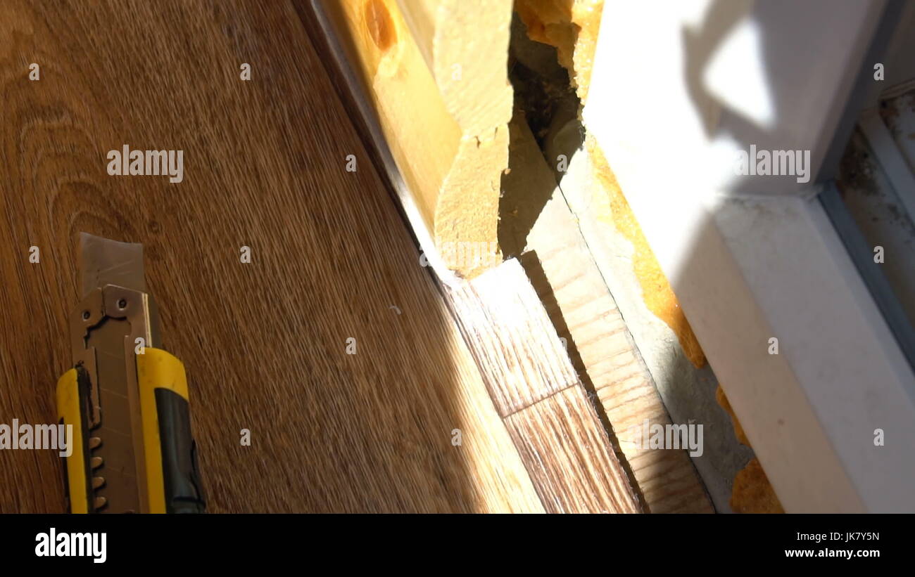 the worker cuts off the linoleum with a utility knife,fitting of ...