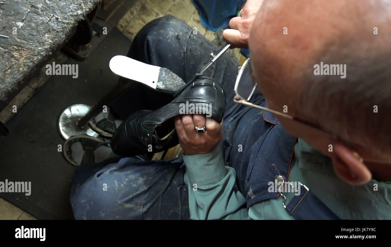 Shoemaker repairing a shoe in workshop 4k. cut the taps on the shoes ...
