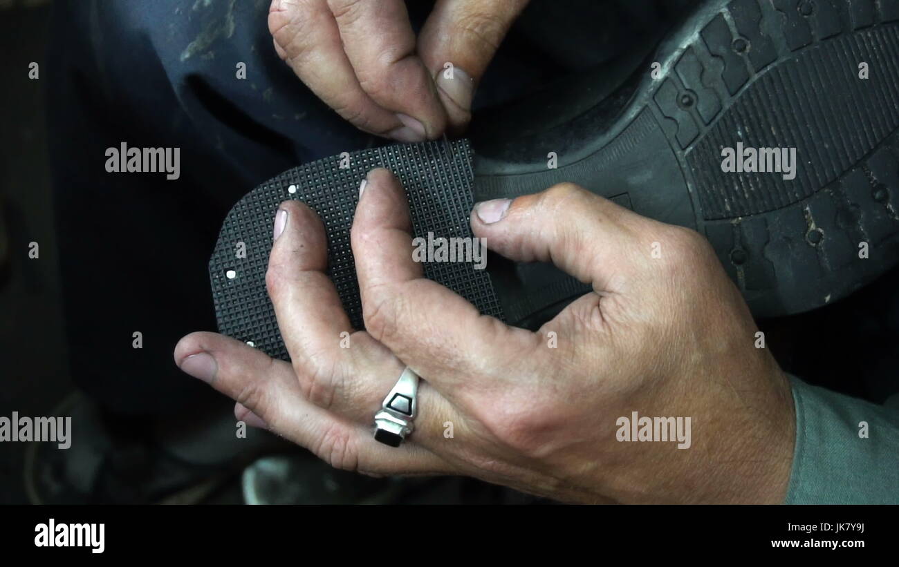 Shoemaker repairing a shoe in workshop 4k nail the heel cap to the heel ...
