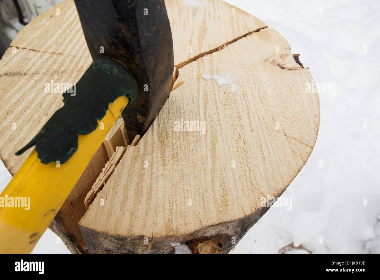 Splitting a pine log with a thick butt axe for winter firewood Stock ...
