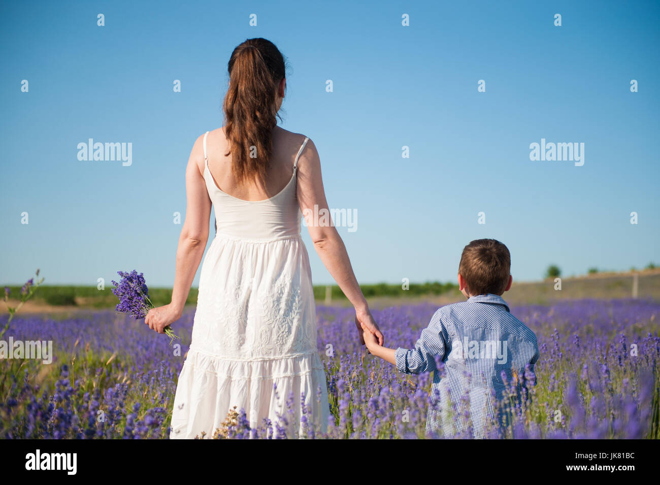 mother holding bouquet of flowers and child holding hands on the ...