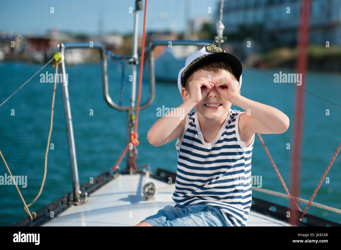 cheerful little boy captain on a luxury yacht in the summer Stock Photo ...