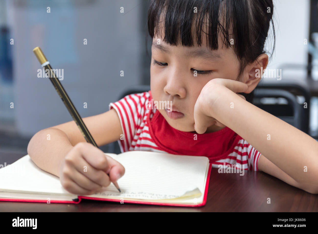 Asian Chinese little girl doing homework at outdoor cafe Stock Photo ...