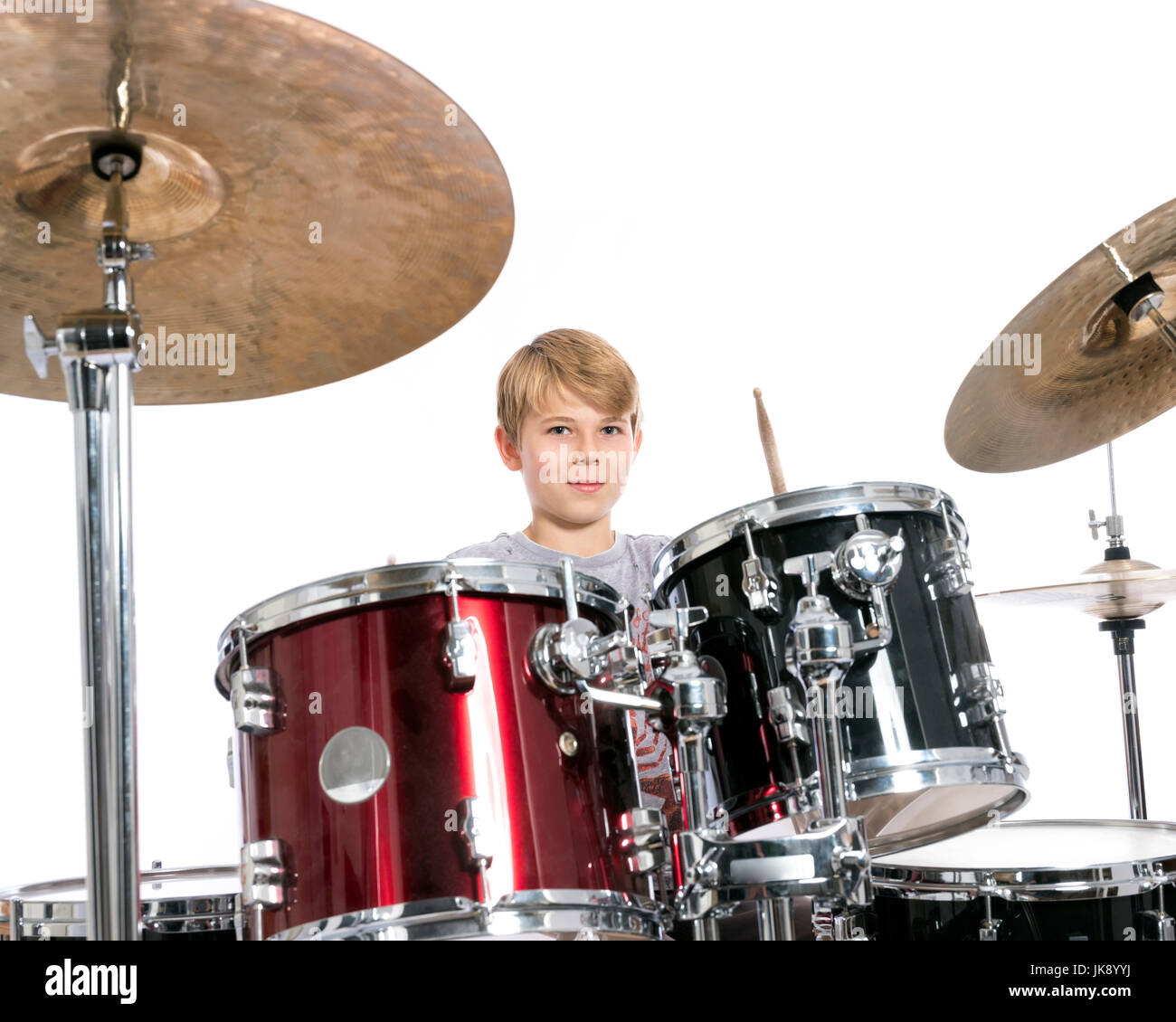 young blond caucasian teen boy plays the drums in studio against white ...