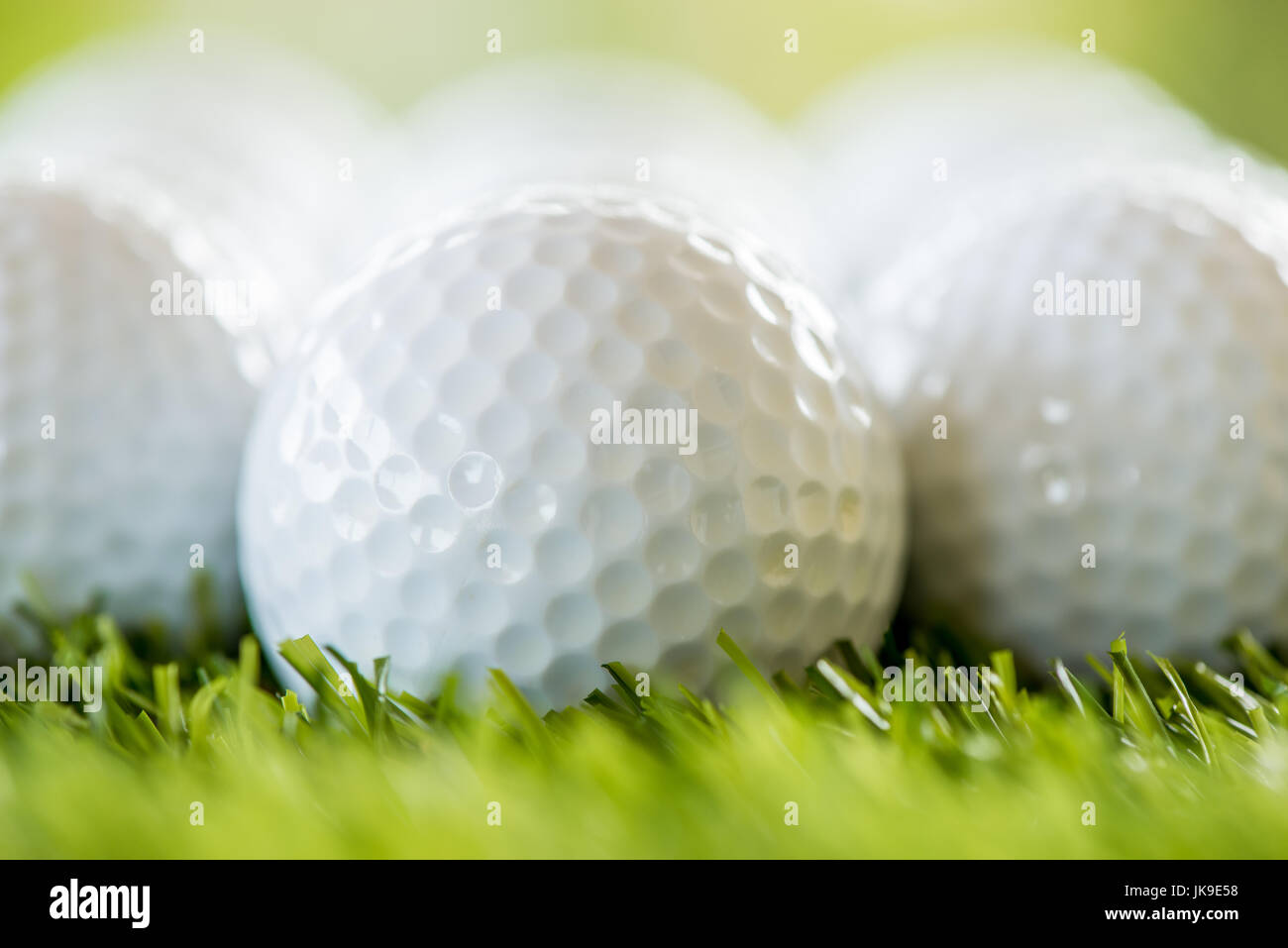 golf ball row on green field Stock Photo - Alamy