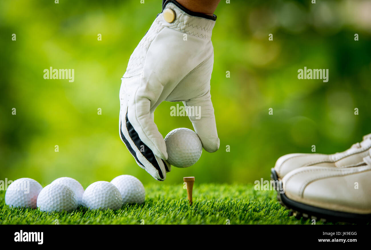 golf players hand placing ball on tee Stock Photo - Alamy