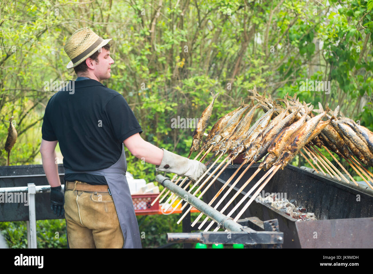 Young man touching fish on a stick like trout,char or whitefisch ...