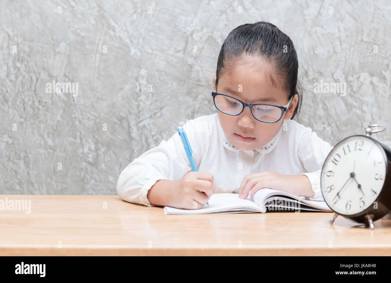 Cute Asian girl student writing her homework on table, education ...