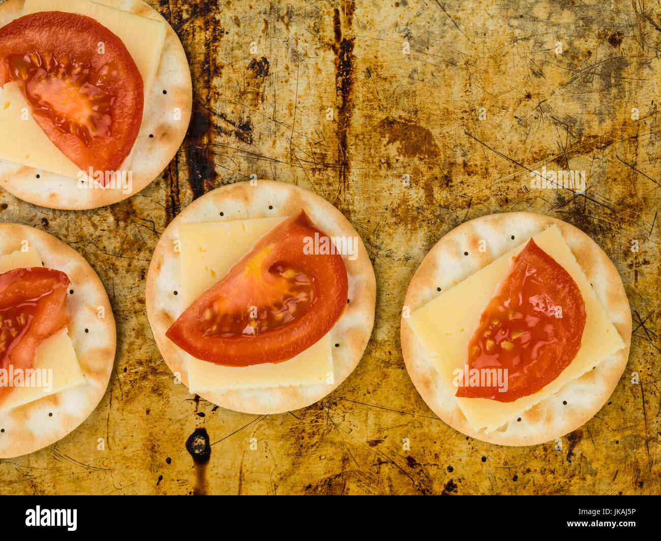 Cheese and Tomato on Water Biscuit Crackers Against a Used Distressed ...