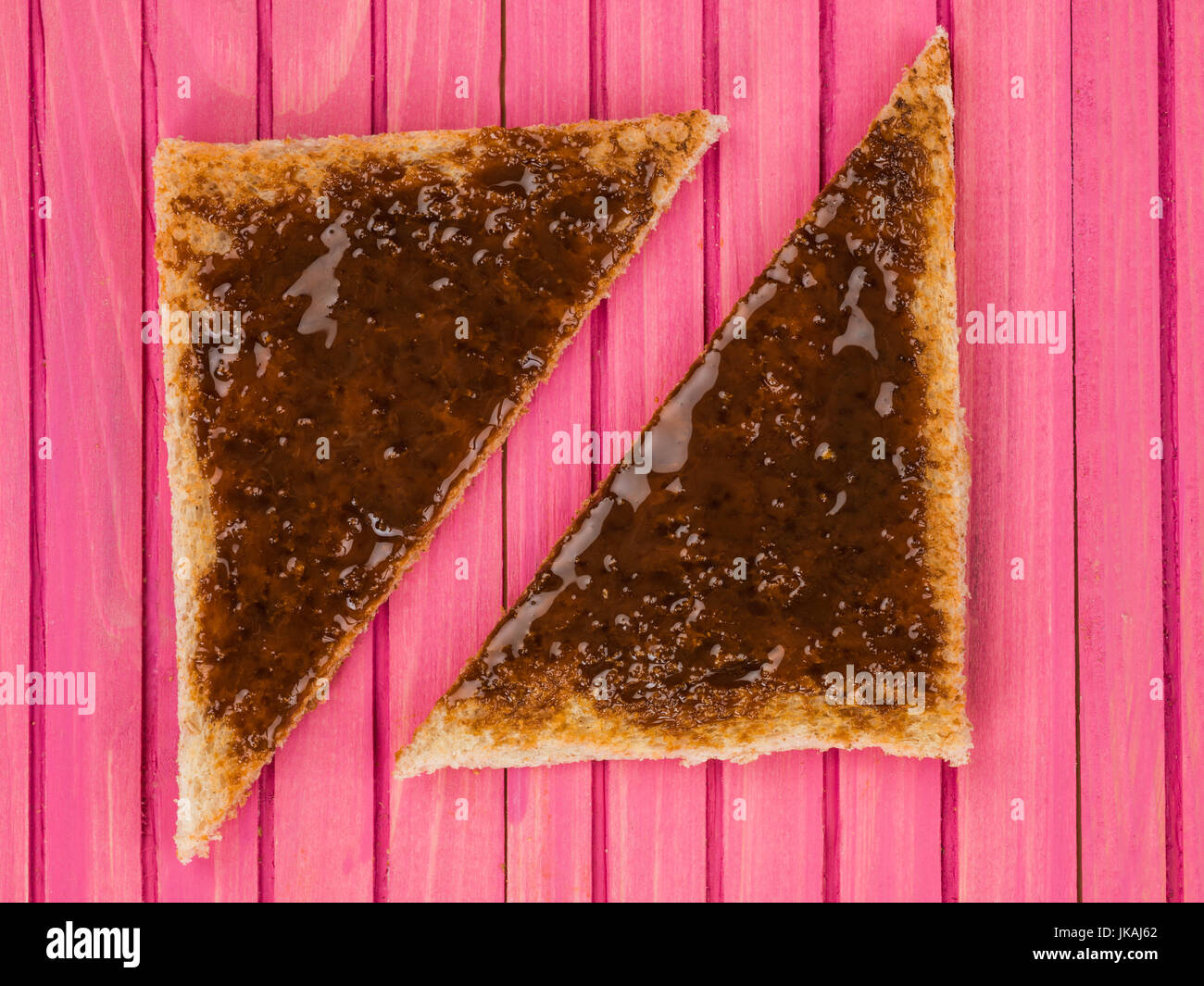 Beef Extract Spread on Toast Against a Pink Wooden Background Stock ...