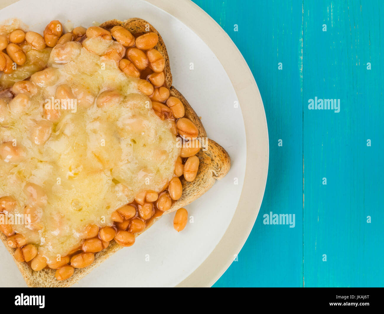 Baked Beans and Melted Cheese on Toast Against a Blue Wooden Background ...