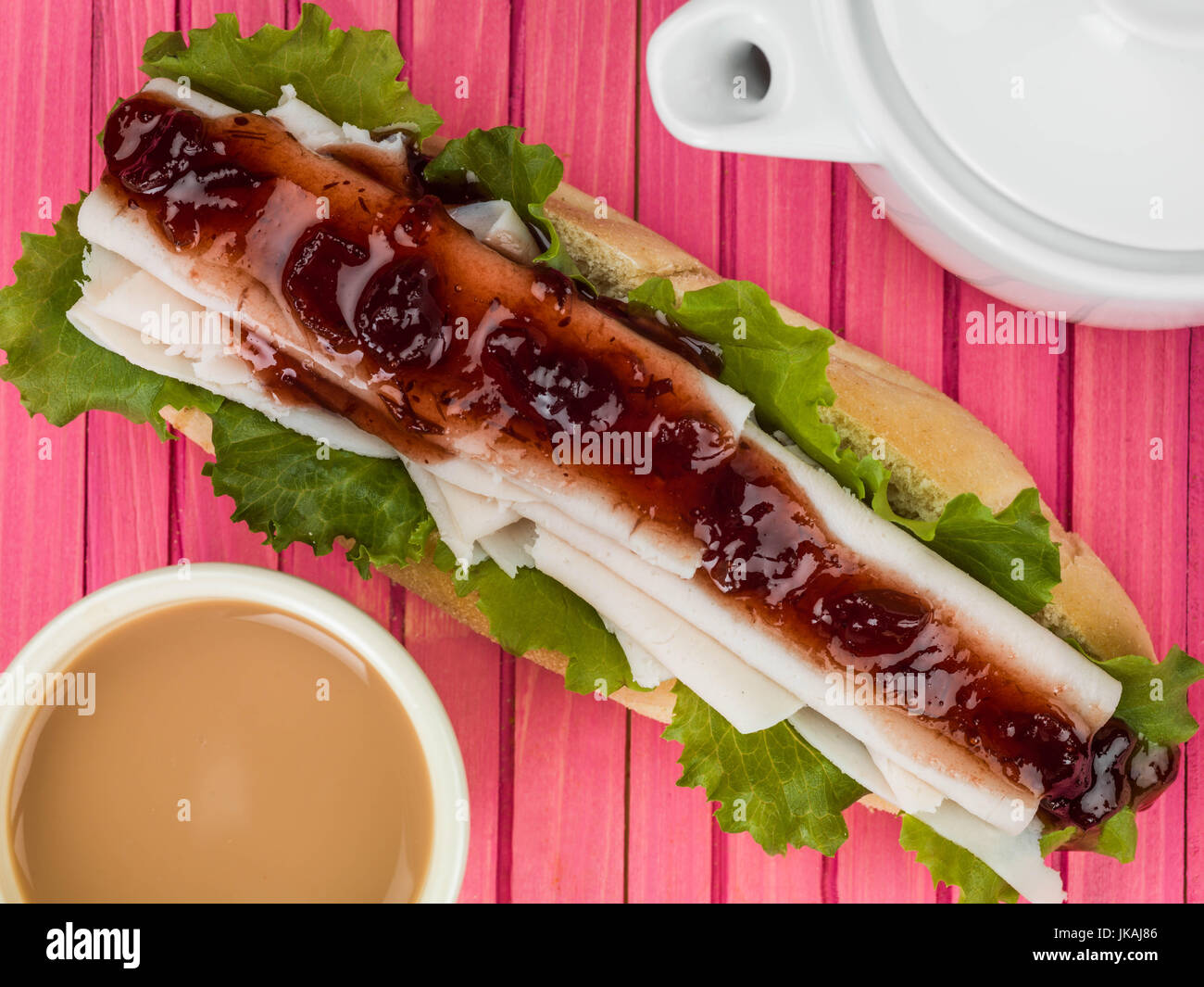 Sliced Roast Turkey and Cranberry Sauce Bread Roll Against a Pink ...