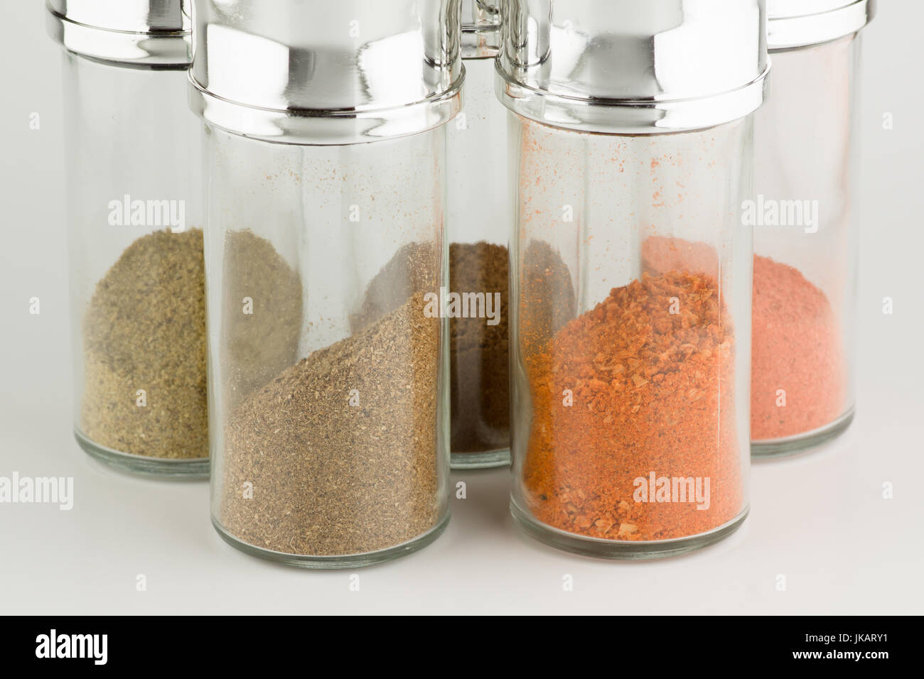 Shredded different color spices in portioned transparent jars Stock ...