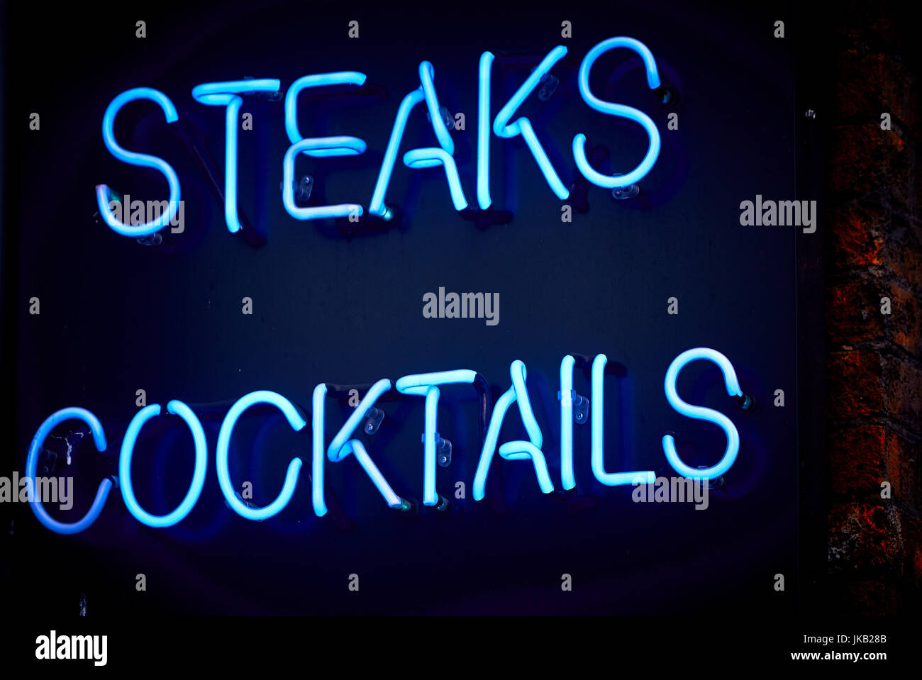 A neon sign advertising steaks and cocktails Stock Photo - Alamy