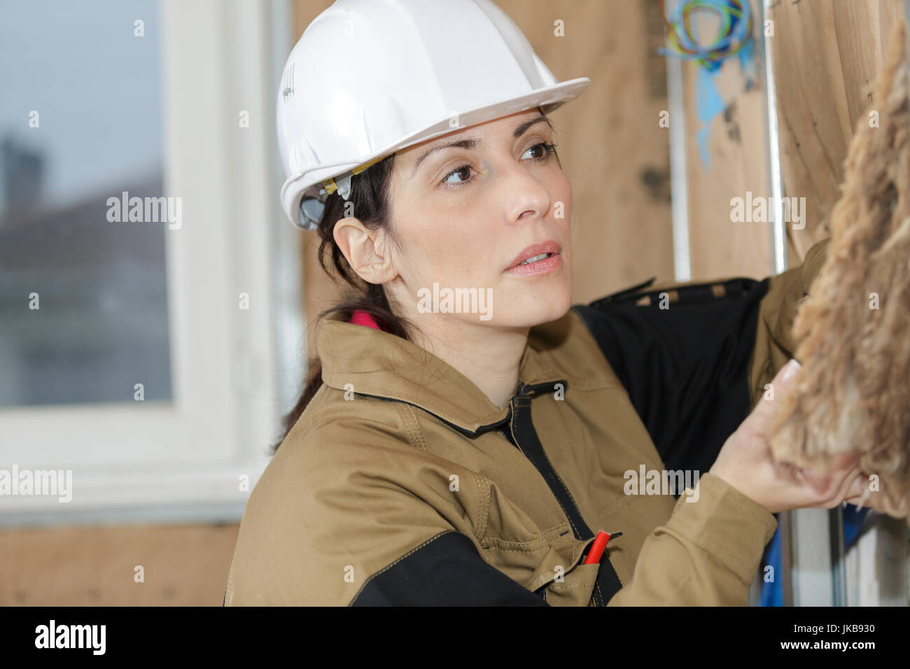 female worker placing styrofoam sheet insulation to wall Stock Photo ...