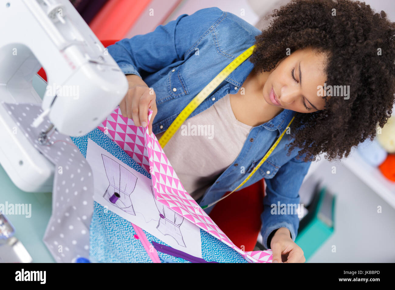 pretty young dressmaker with sewing machine Stock Photo - Alamy