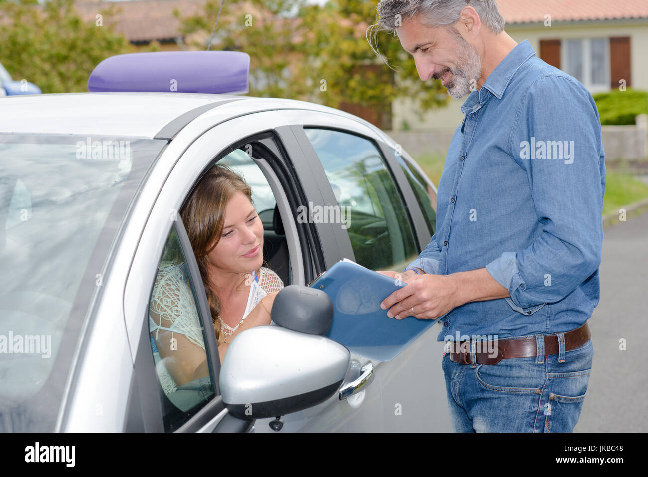 happy woman taking driving lessons from instructor Stock Photo - Alamy