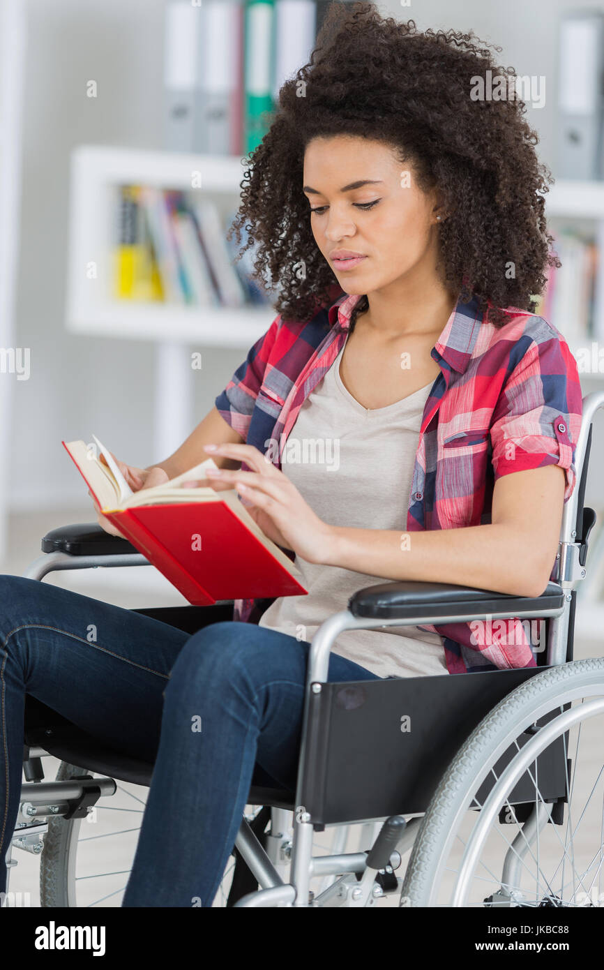 woman in wheelchair reading a book Stock Photo - Alamy