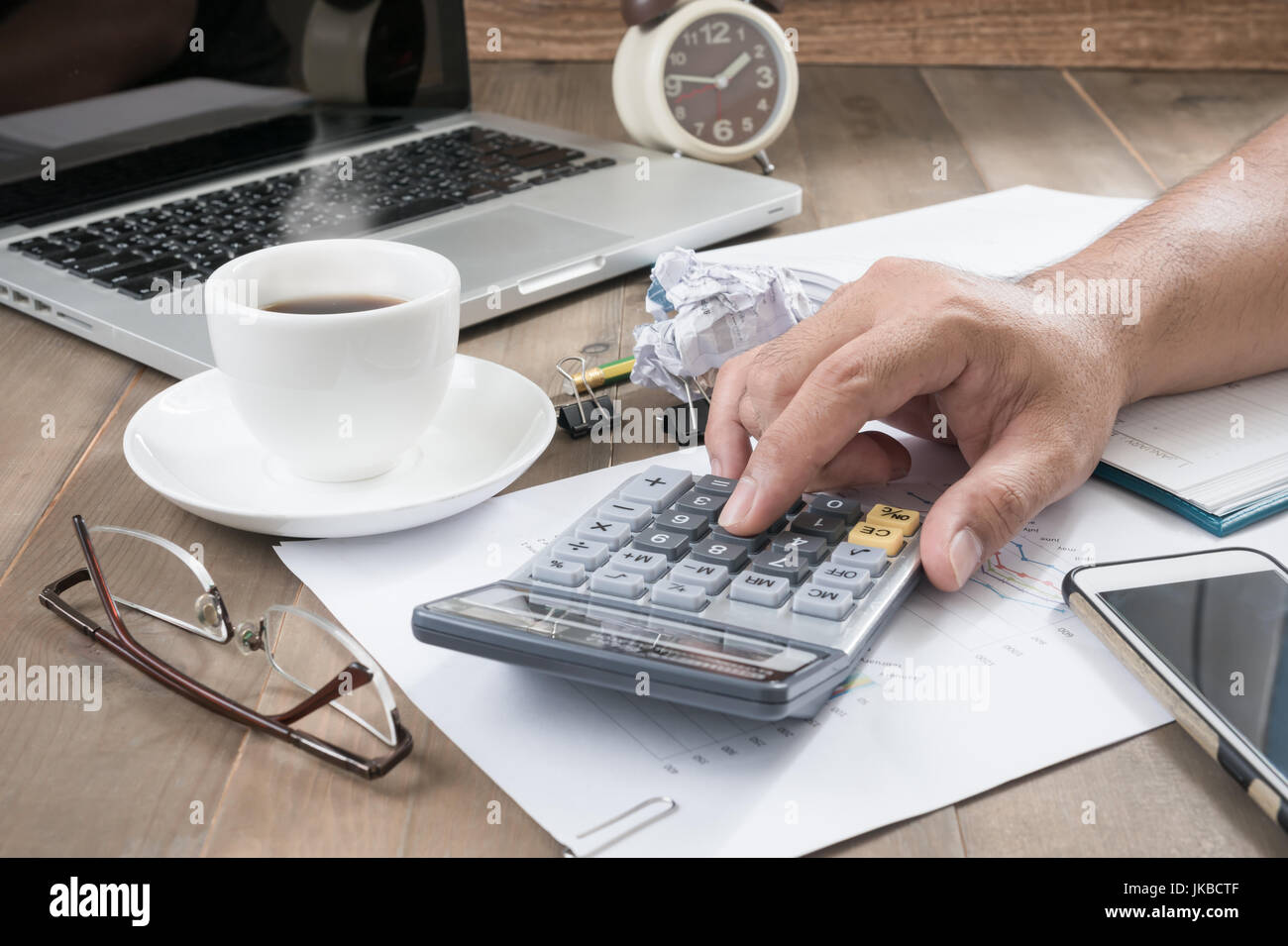 business man using calculator with hot coffee and computer notebook on ...