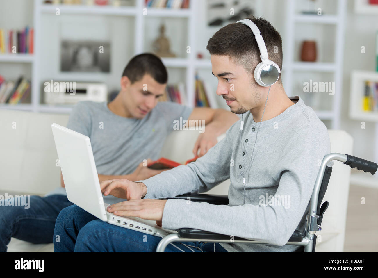 two young men doing their homework in the living room Stock Photo - Alamy