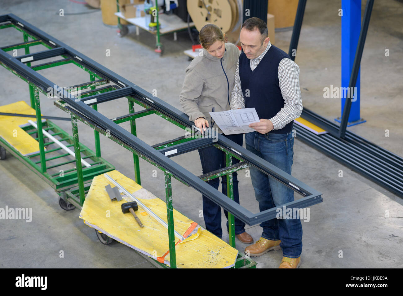 interior of busy factory with staff at work benches Stock Photo - Alamy