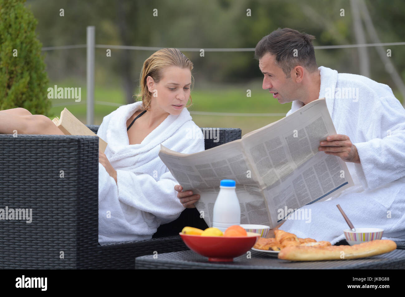 couple reading a newspaper together Stock Photo - Alamy