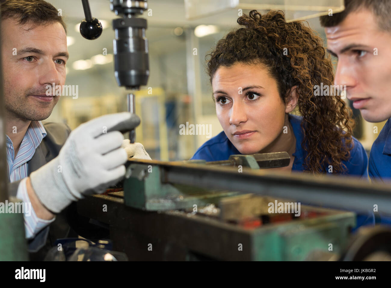 engineer and apprentices using automated milling machine Stock Photo ...